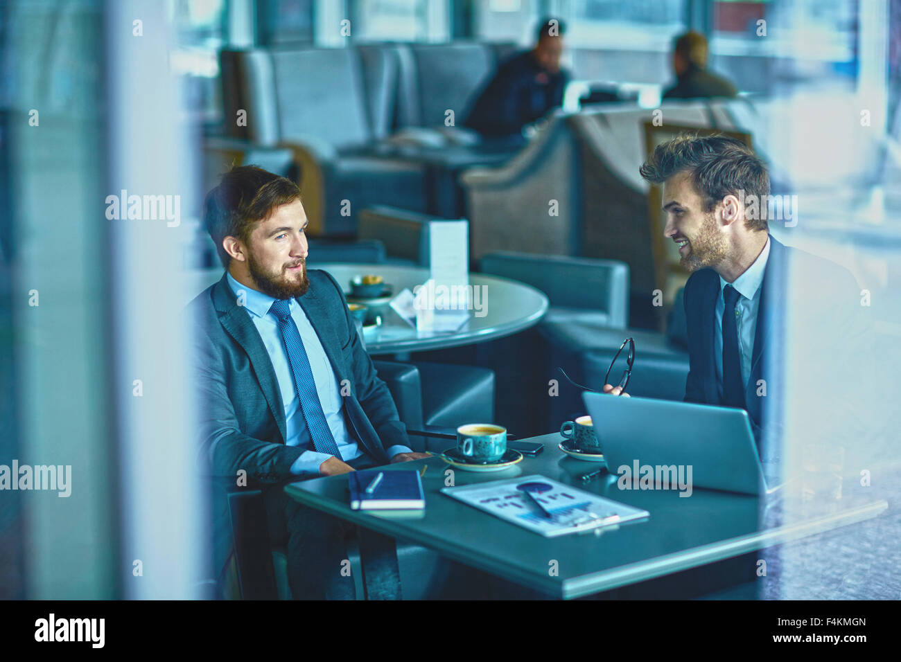Two male employees consulting in cafe Stock Photo - Alamy