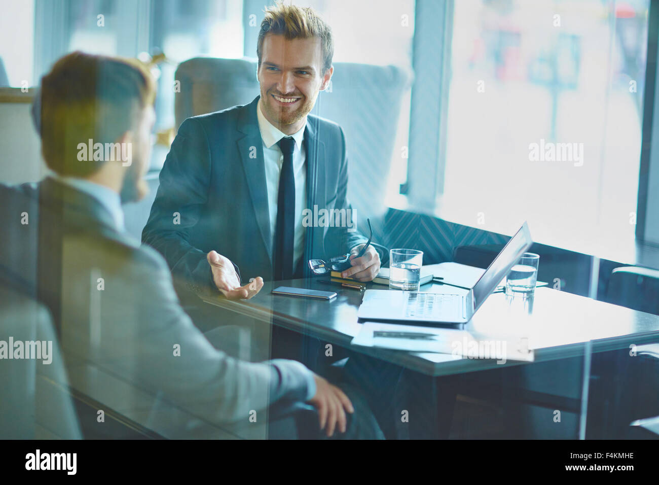 Happy employee discussing idea to colleague in office Stock Photo - Alamy