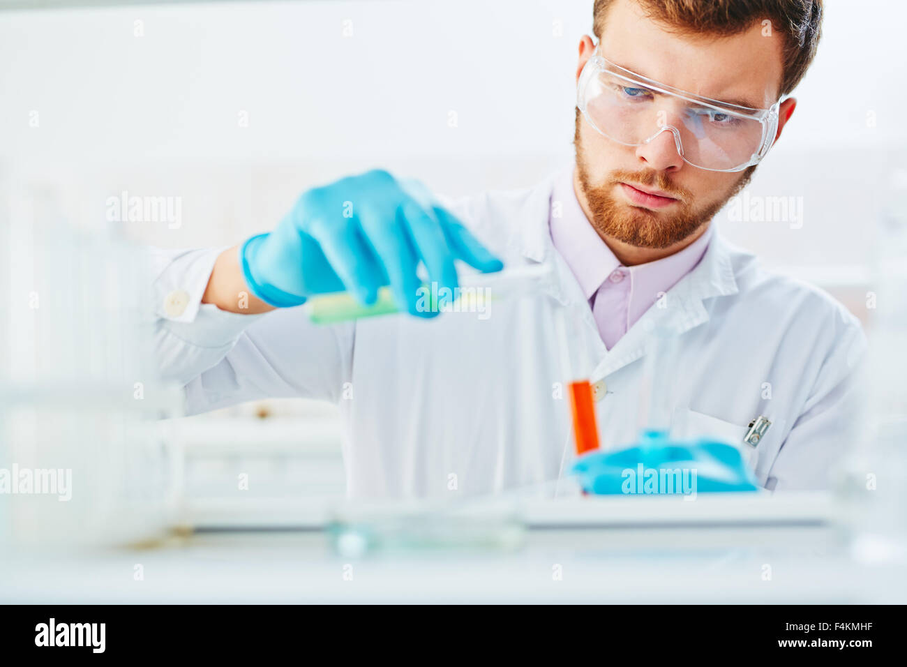 Male chemist mixing up liquid substances in laboratory Stock Photo - Alamy