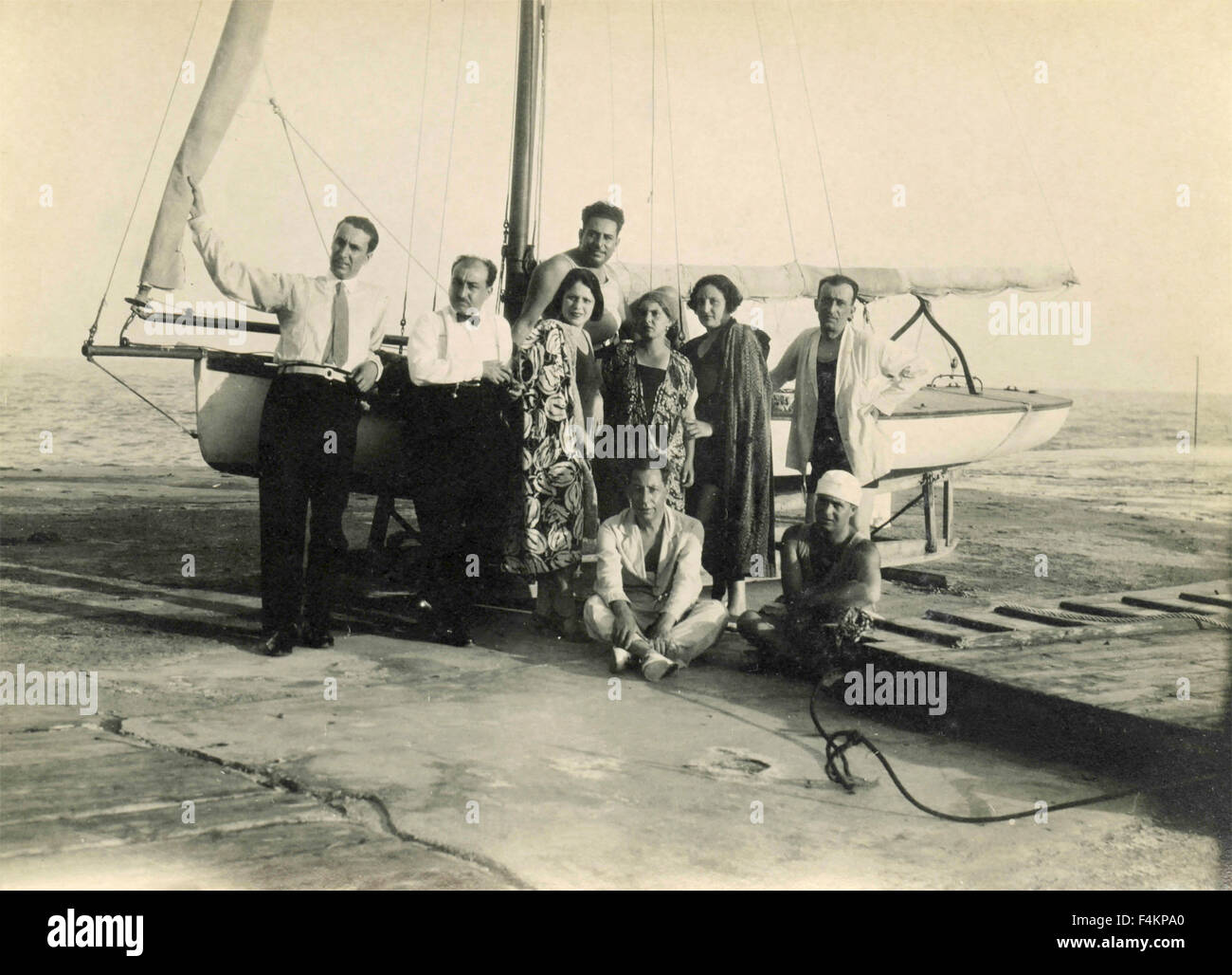 Group of friends around a sailing boat, Italy Stock Photo - Alamy