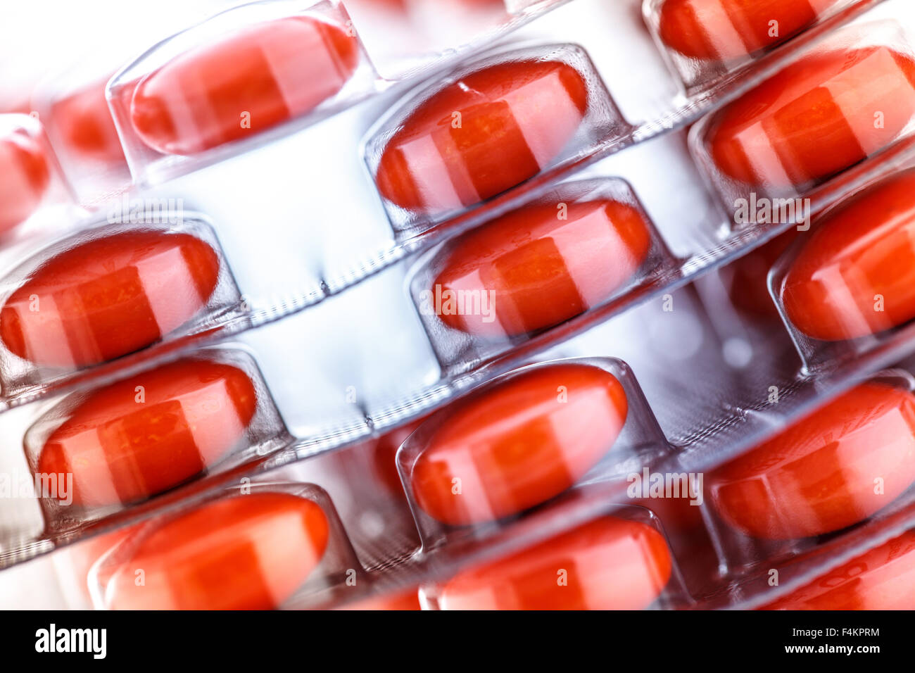 Red tablets in plastic packing as background Stock Photo - Alamy