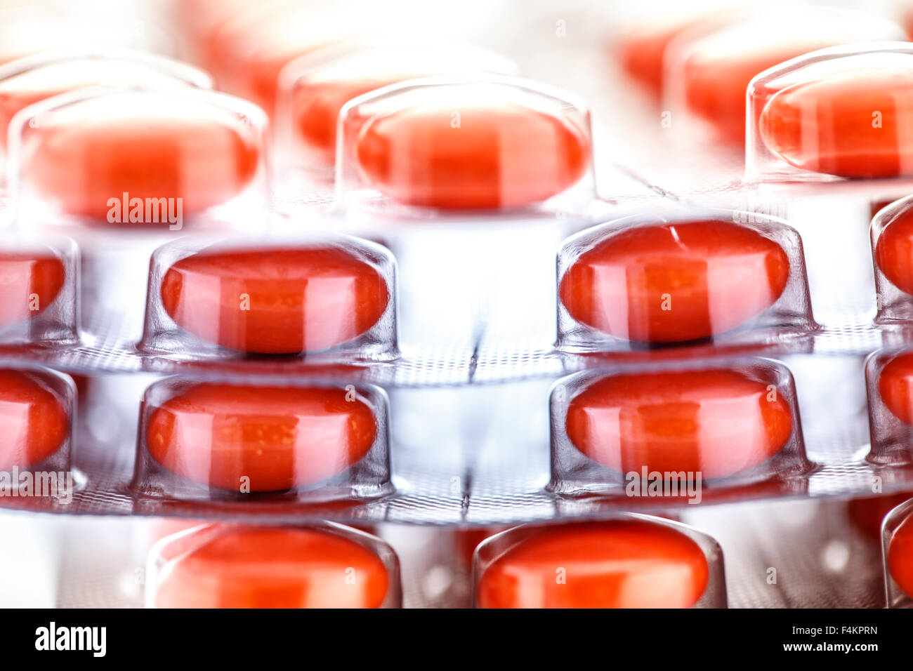 Red tablets in plastic packing as background Stock Photo - Alamy