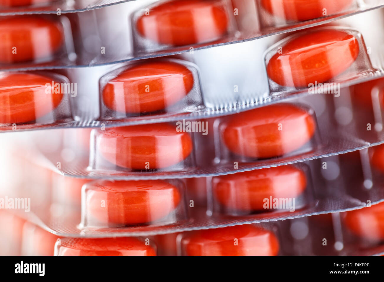 Red tablets in plastic packing as background Stock Photo - Alamy