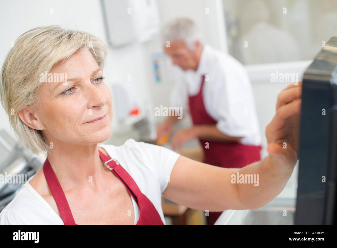 Woman using a touch screen till system Stock Photo - Alamy