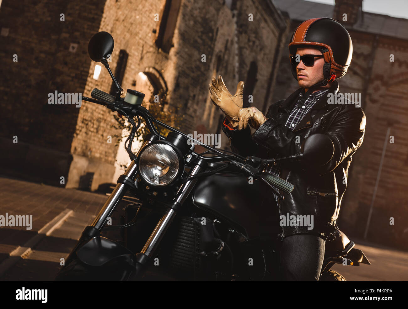 Man sitting on a cafe-racer motorcycle outdoors Stock Photo - Alamy
