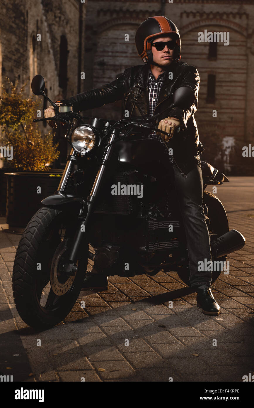 Man sitting on a cafe-racer motorcycle outdoors Stock Photo - Alamy