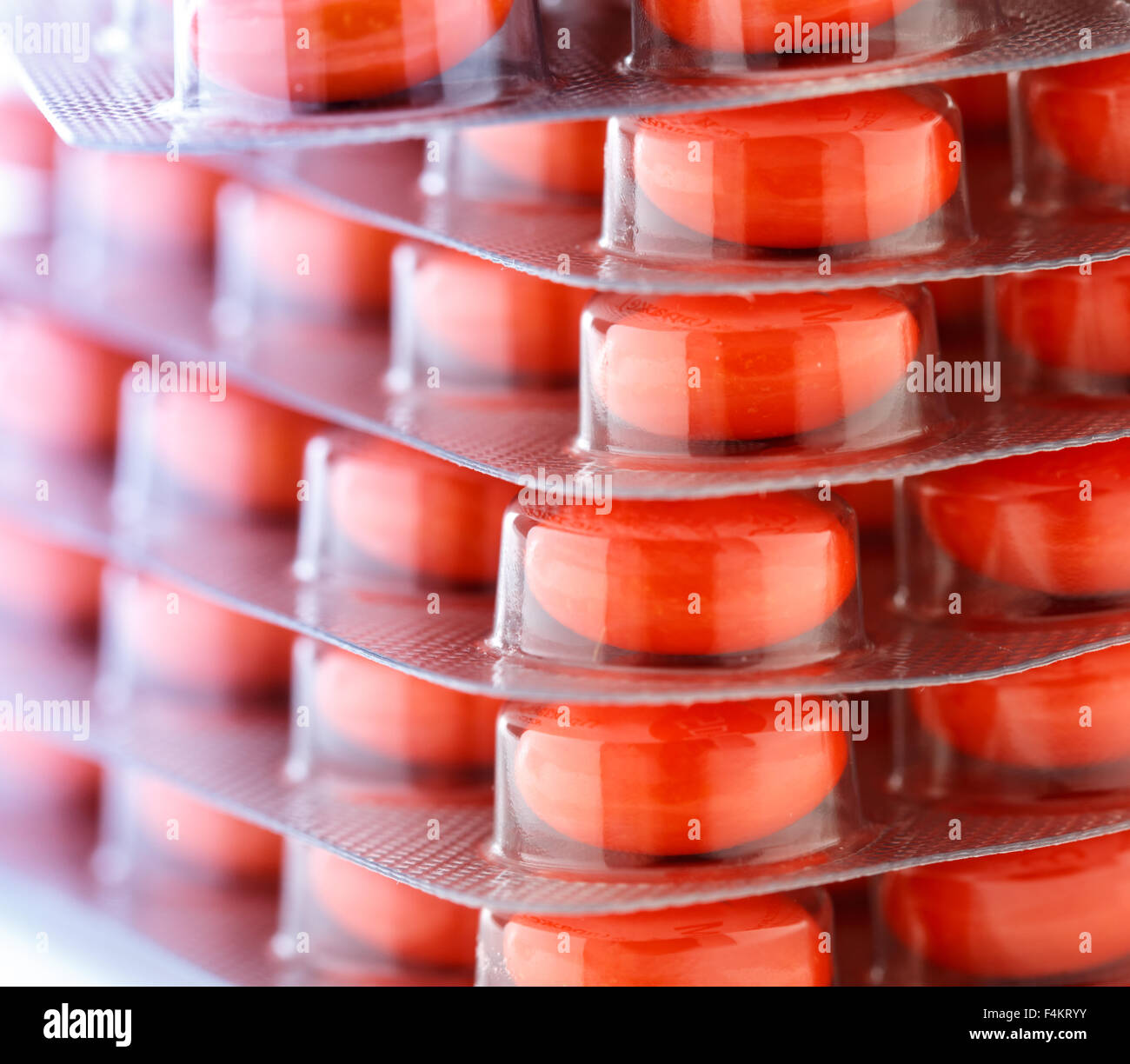 Red tablets in plastic packing as background Stock Photo - Alamy