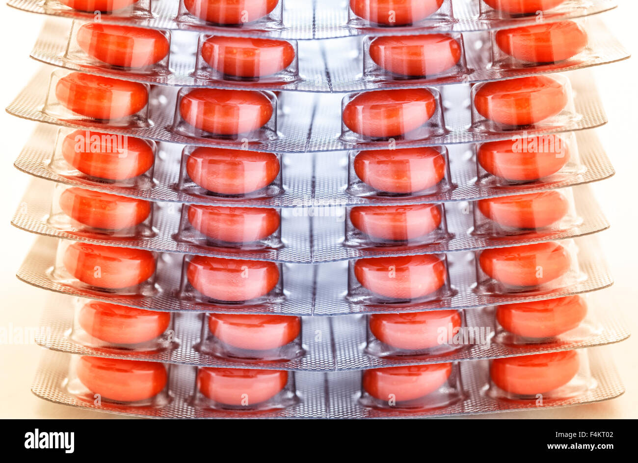 Red tablets in plastic packing as background Stock Photo - Alamy