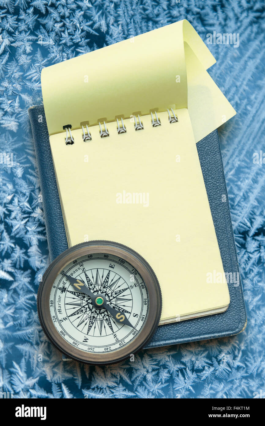 Vintage compass and blank yellow notepad open Stock Photo - Alamy