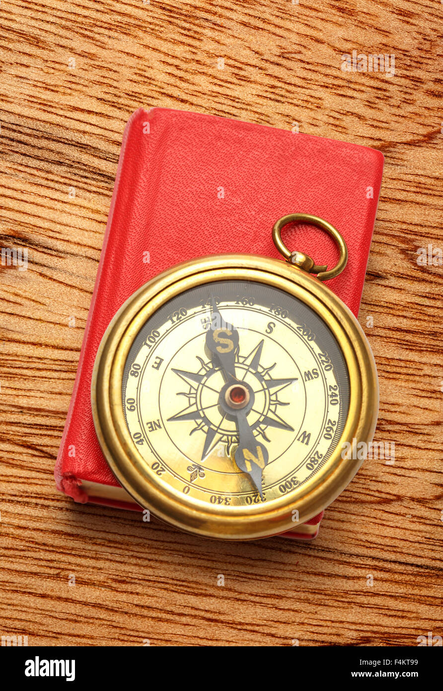 Red closed book with retro compass on it Stock Photo - Alamy