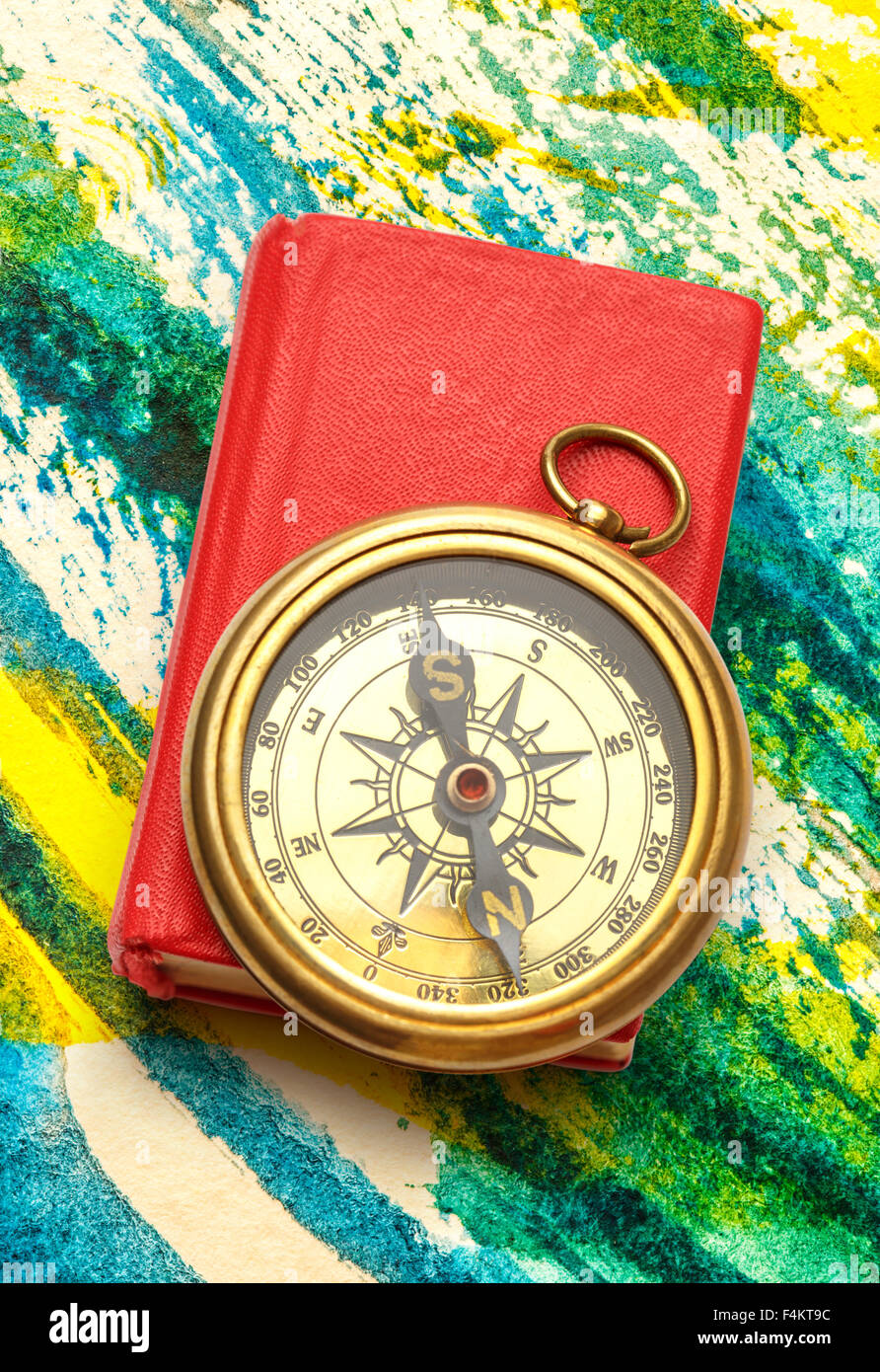 Red closed book with retro compass on it Stock Photo - Alamy