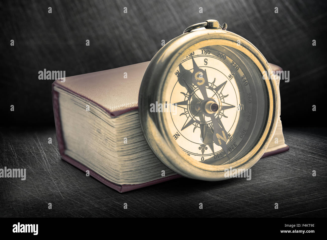 Red closed book with retro compass on it Stock Photo - Alamy