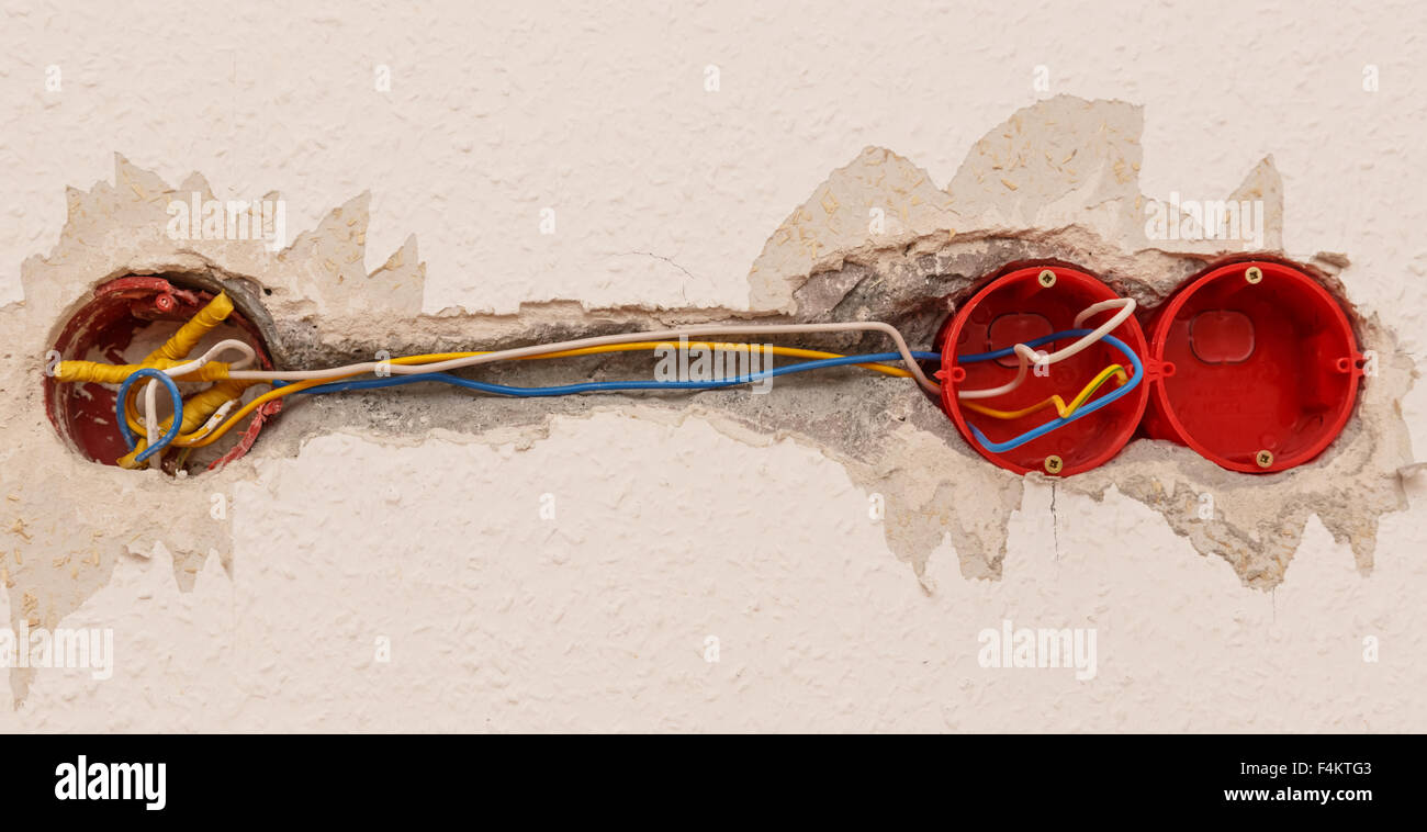 Electricity socket installation on white wall closeup Stock Photo - Alamy