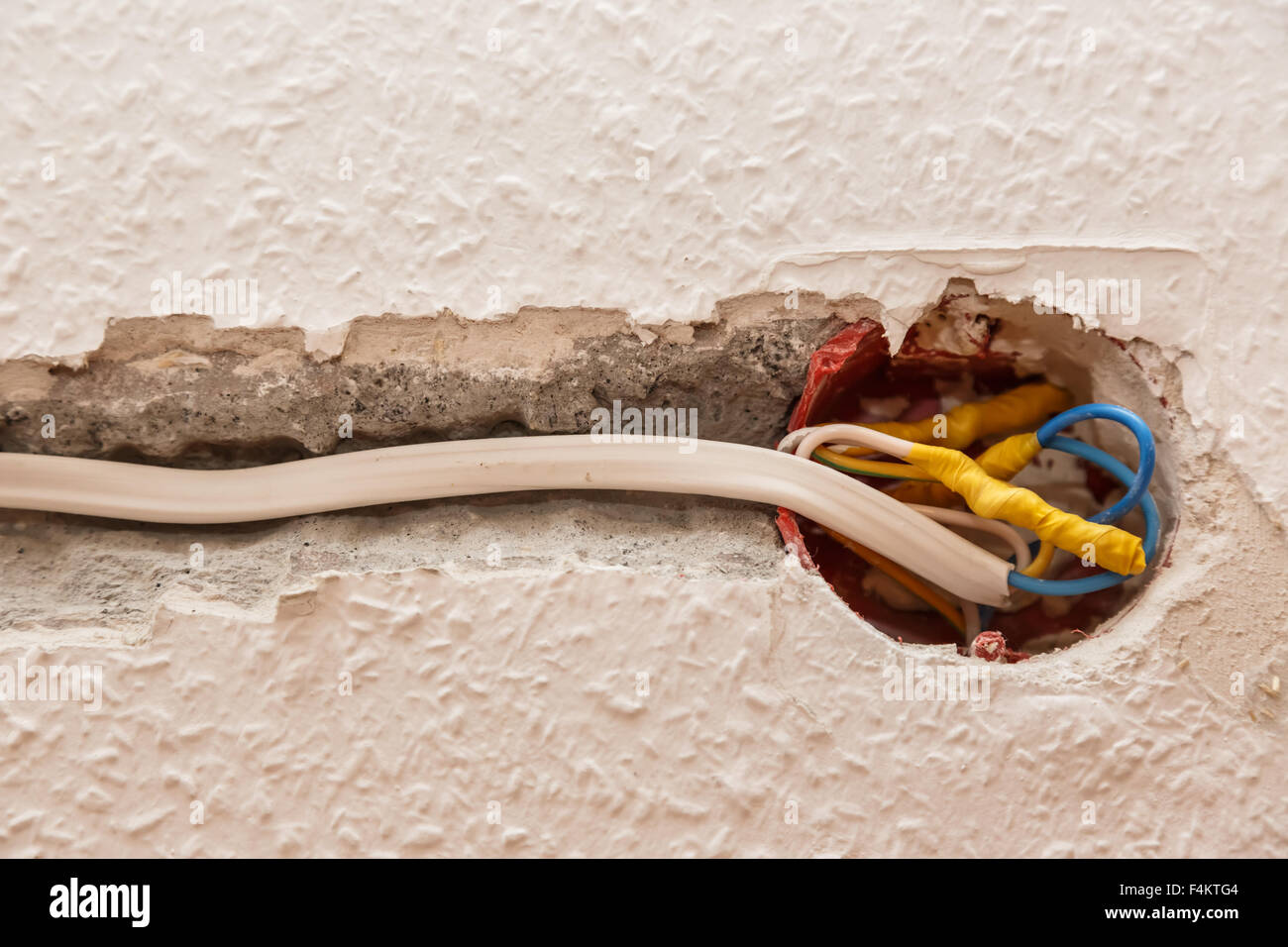 Electricity socket installation on white wall closeup Stock Photo - Alamy