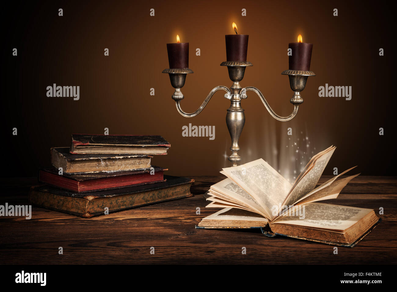 Old vintage books with candles in candlestick Stock Photo - Alamy