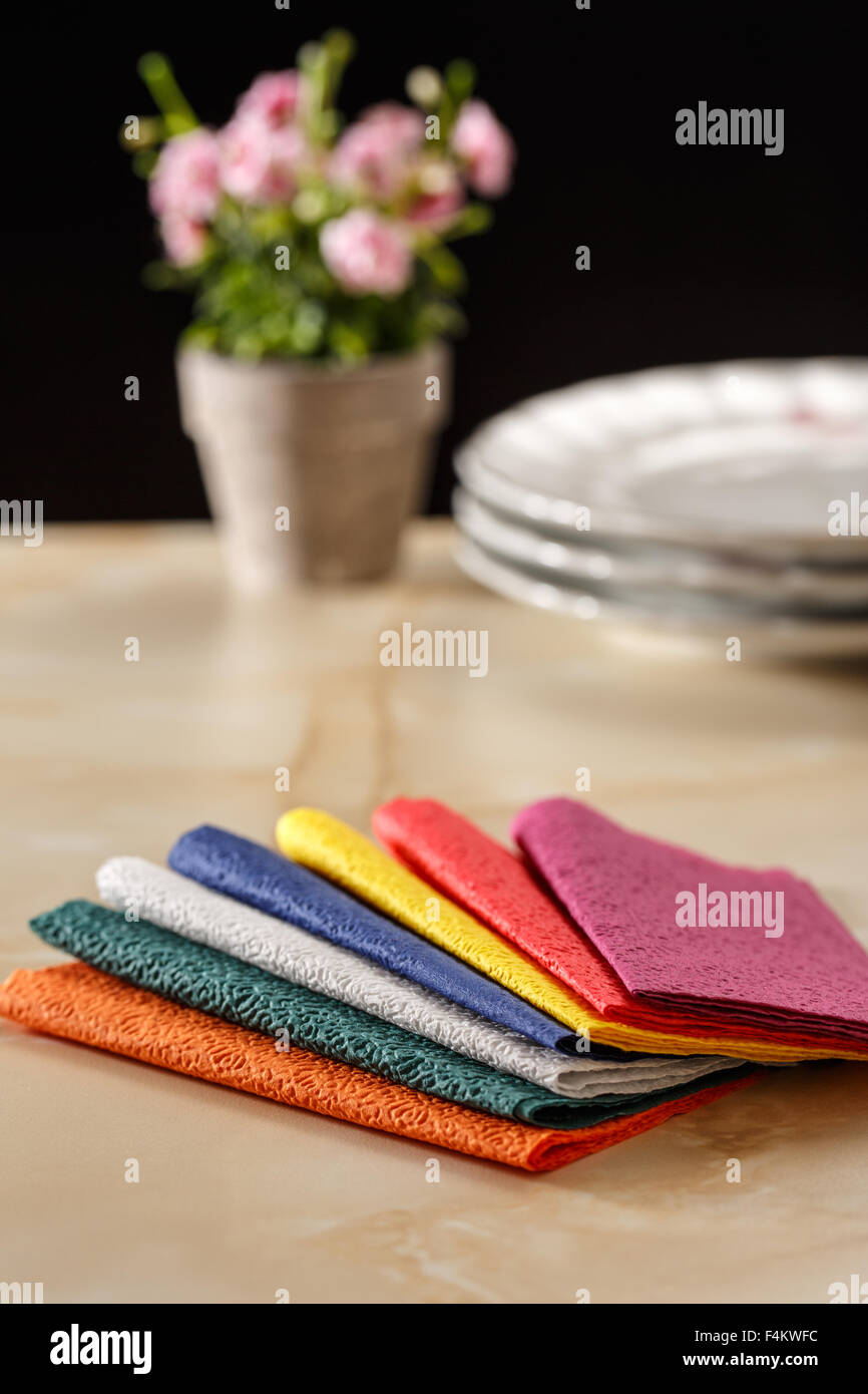 Still life with colorful paper table napkins, flowers and plates Stock ...