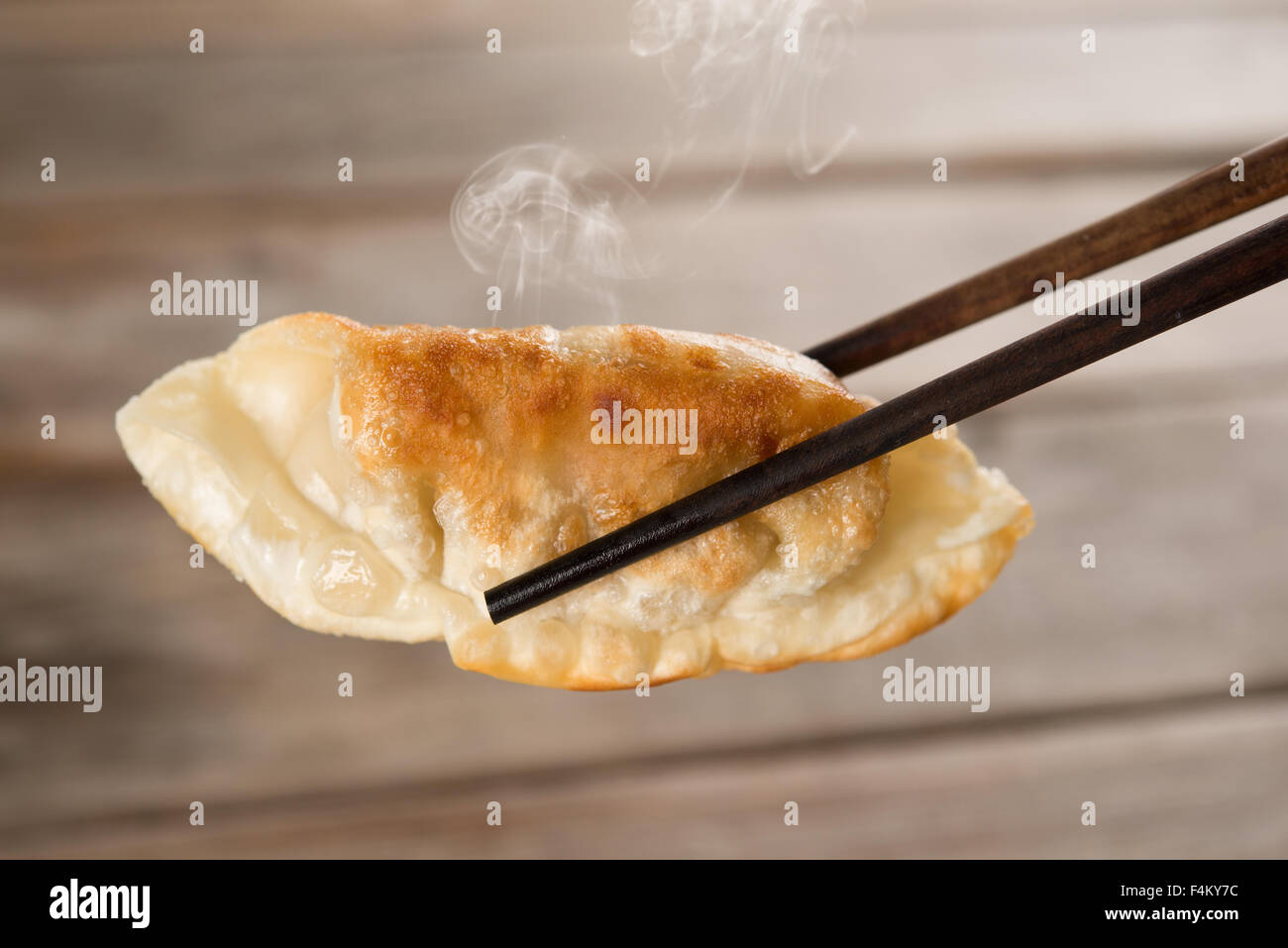 Close up fresh pan fried dumpling with chopsticks. Chinese food with ...