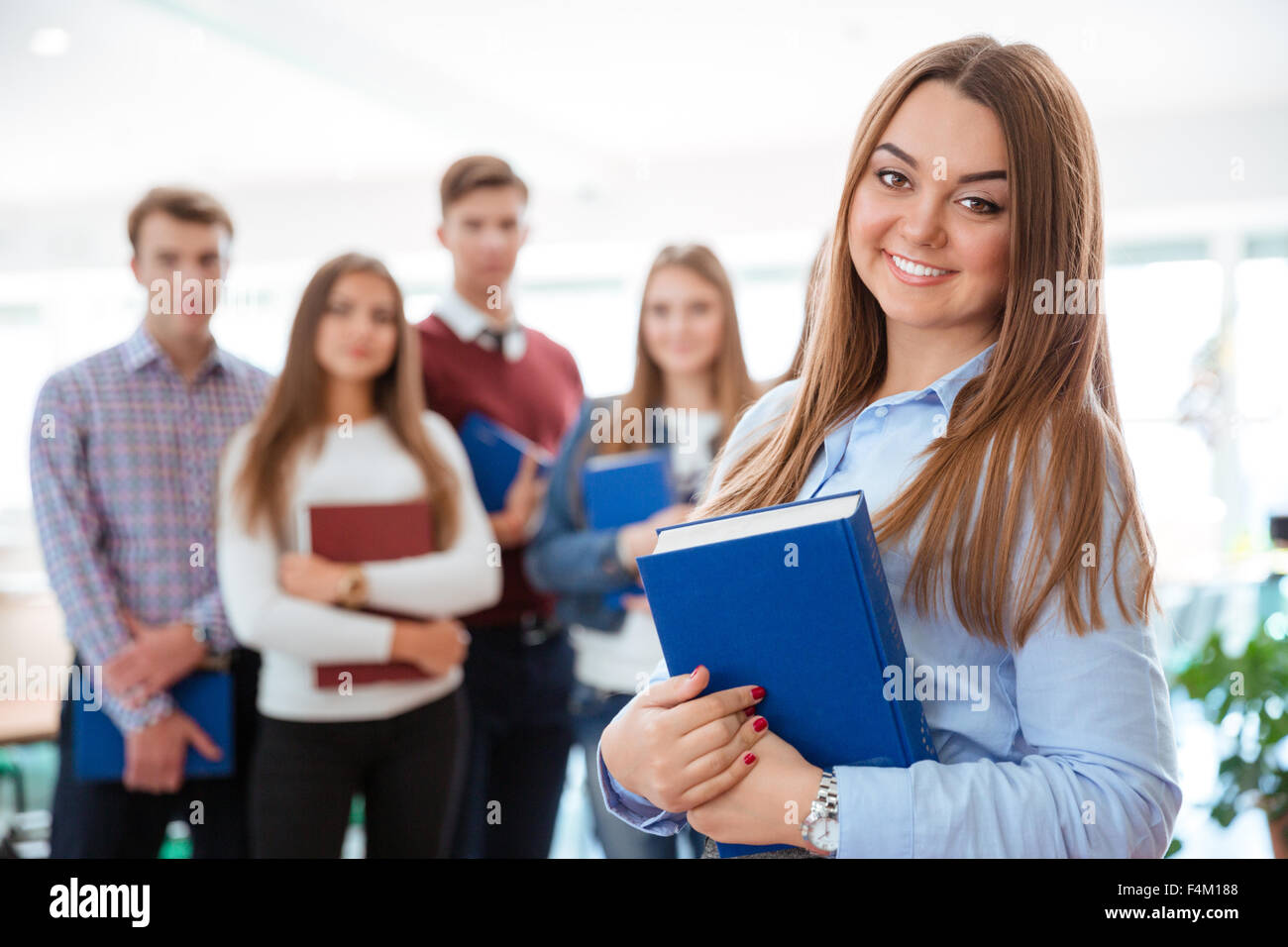 Portrait of a happy beautiful woman standing in classroom with ...