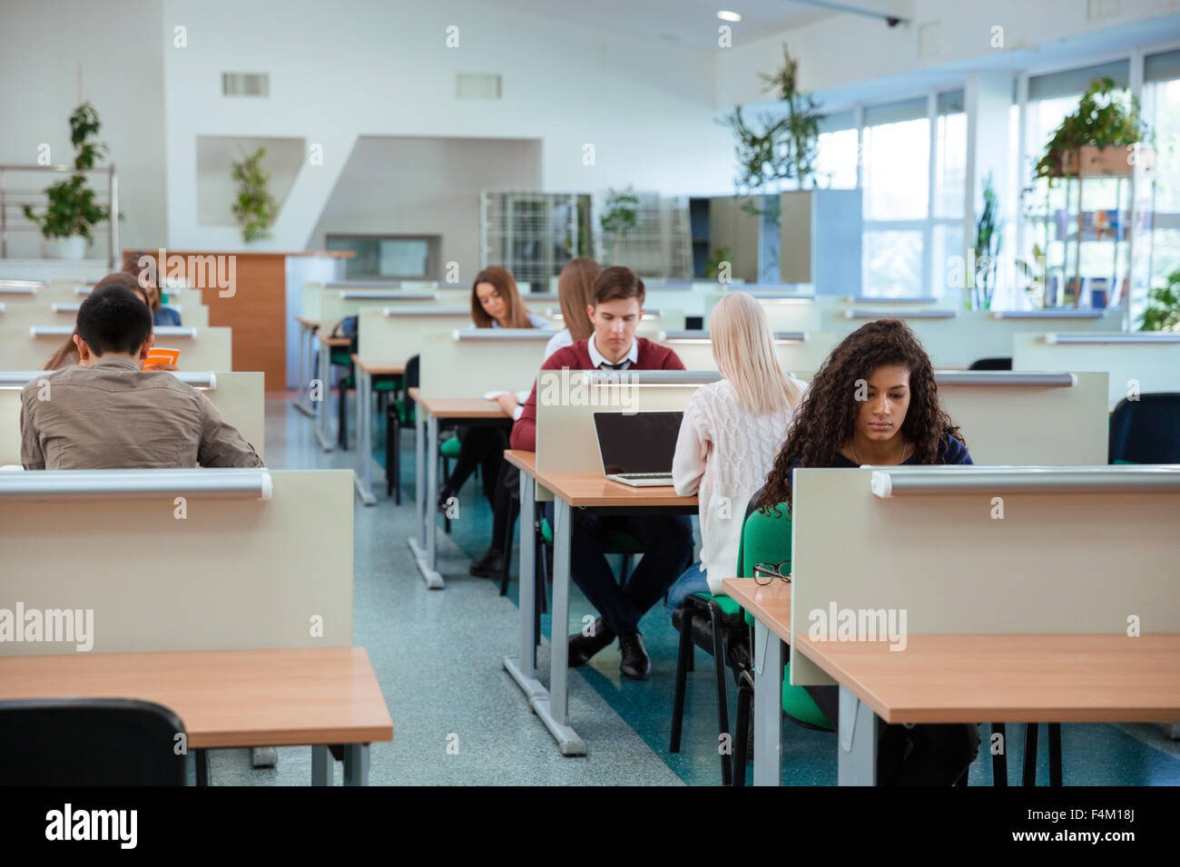 Portrait of a students studying in library Stock Photo - Alamy