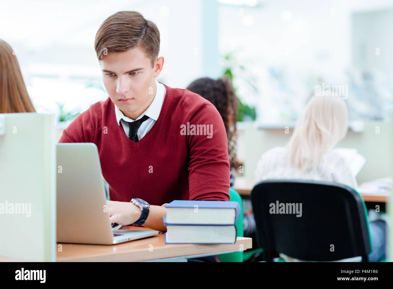 Portrait of a handsome man using laptop computer in university library ...