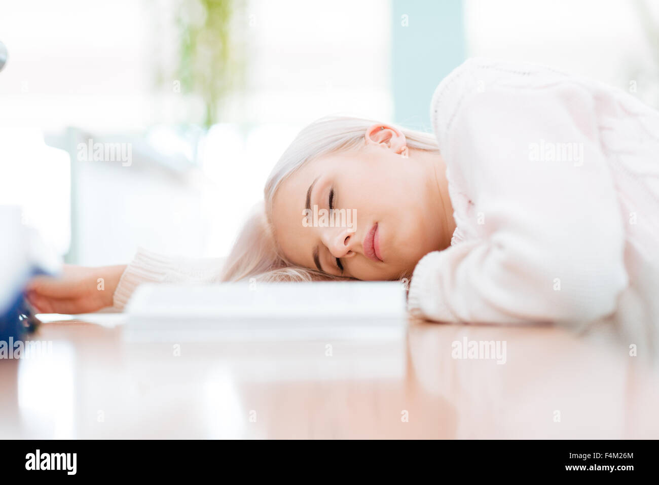 Portrait of a young female student sleeping on the table Stock Photo ...