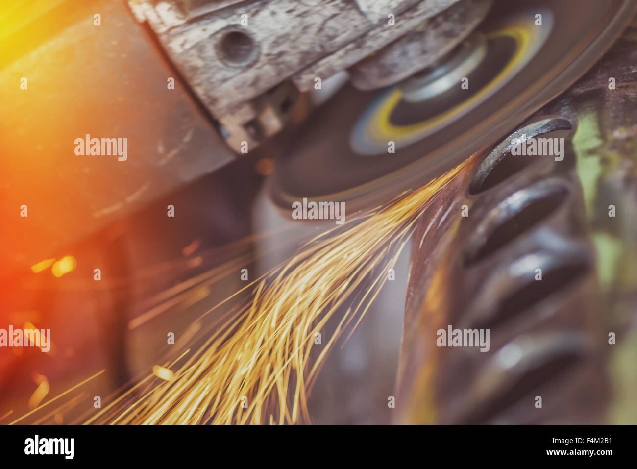 Worker grinding steel pipe, man using grinder to work on piece of metal ...