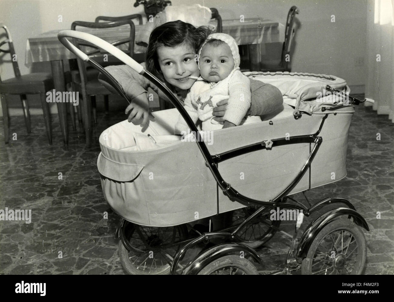 Two sisters, one in a pram Stock Photo - Alamy