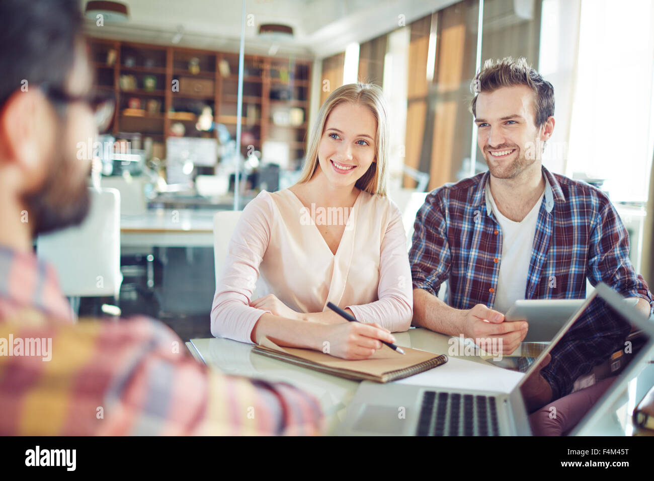 Confident colleagues listening to businessman while planning work Stock ...