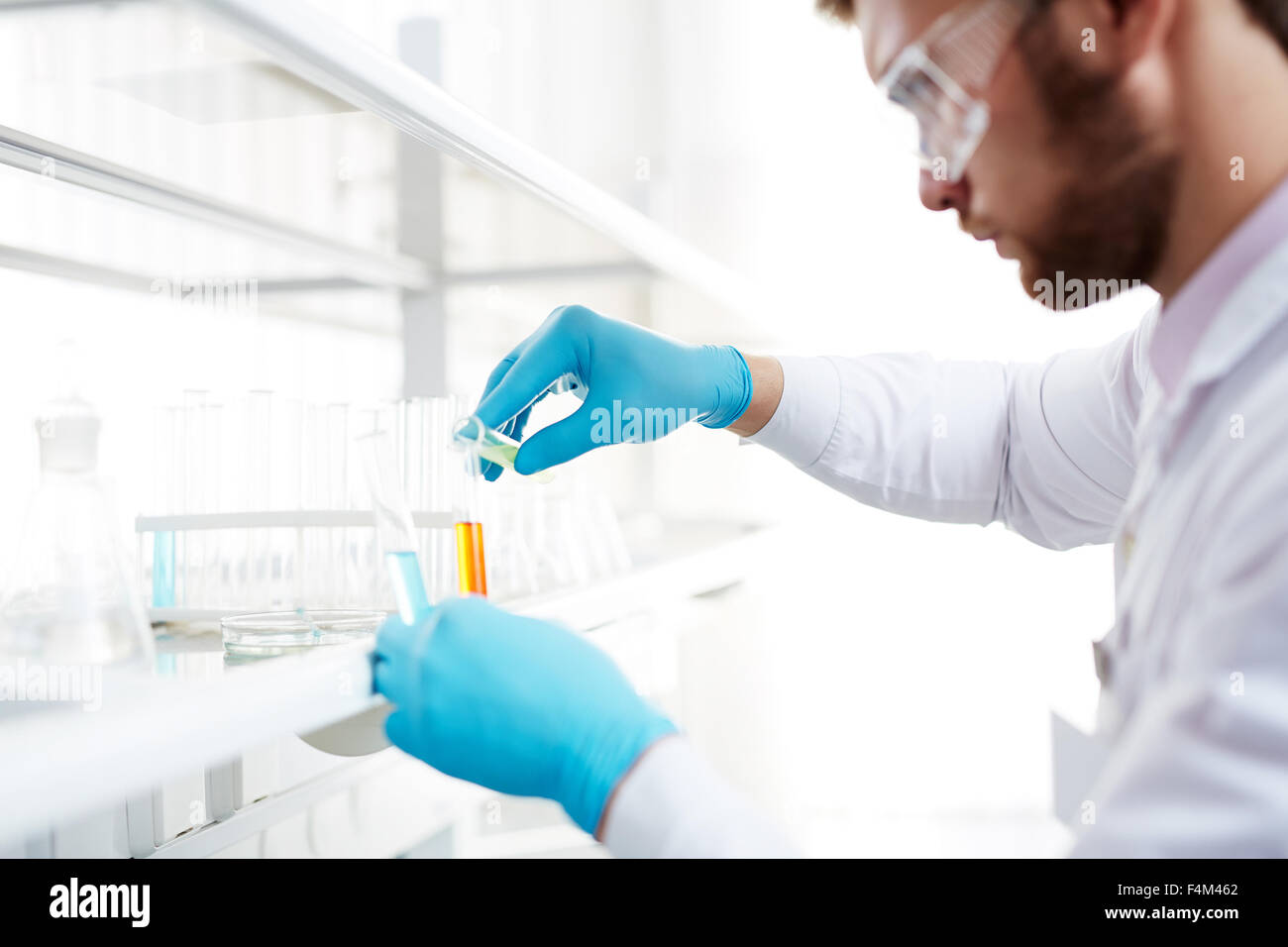 Male chemist mixing up liquid substances in laboratory Stock Photo - Alamy