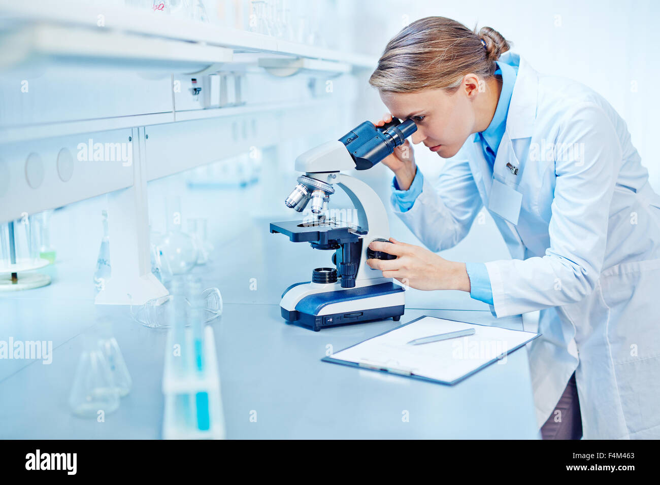 Young scientist studying new substance or virus in microscope Stock ...