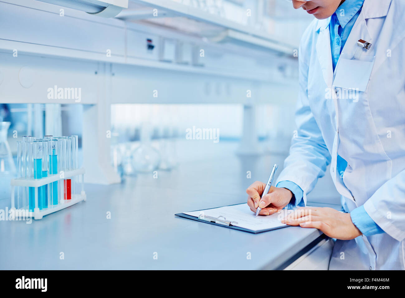 Female lab worker making notes Stock Photo - Alamy