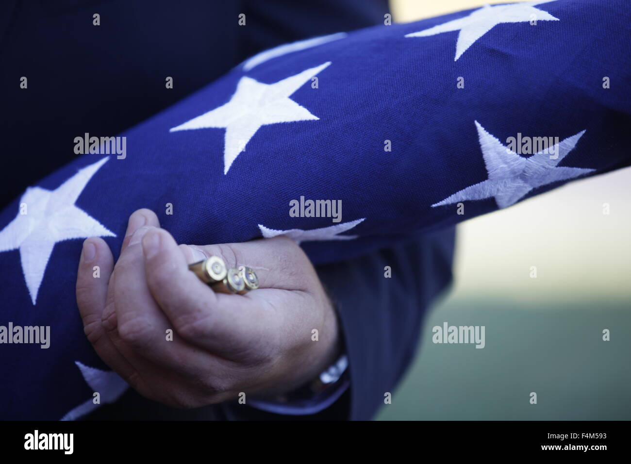 Holding the folded flag and three spent shells after the 21 gun salute ...