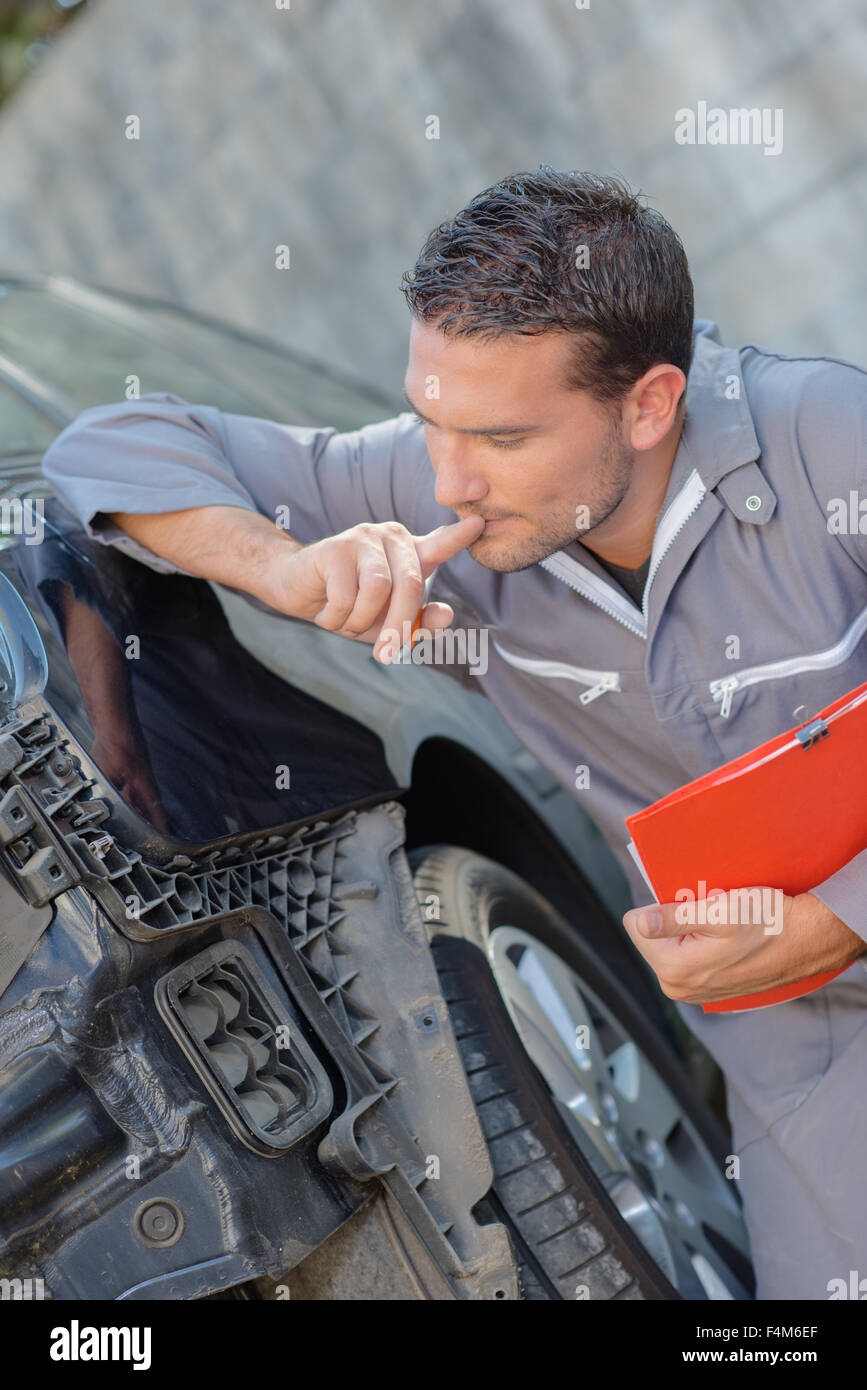 Mechanic assessing car Stock Photo - Alamy