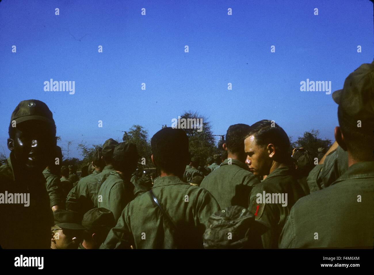 Soldiers gathered at a First Infantry Division base camp in 1965 during ...