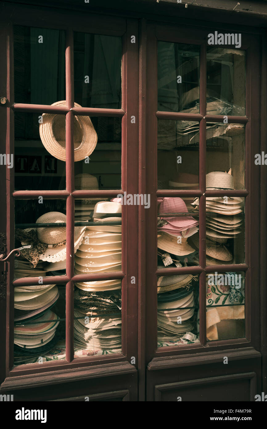 Hats piled up inside shop window in France Stock Photo - Alamy