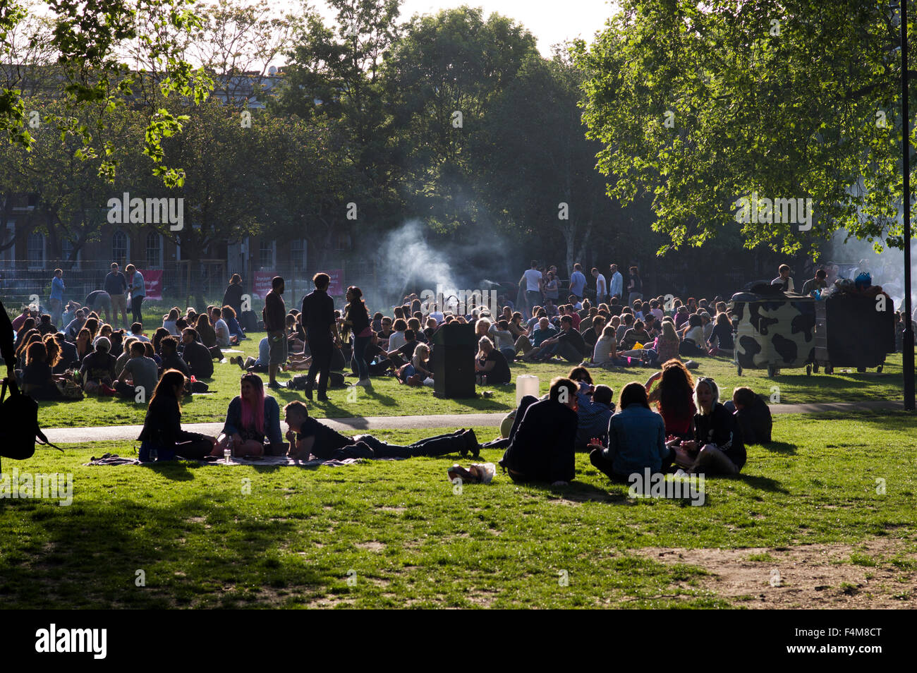 Large group of people in London Fields park on a sunny day, sitting on ...