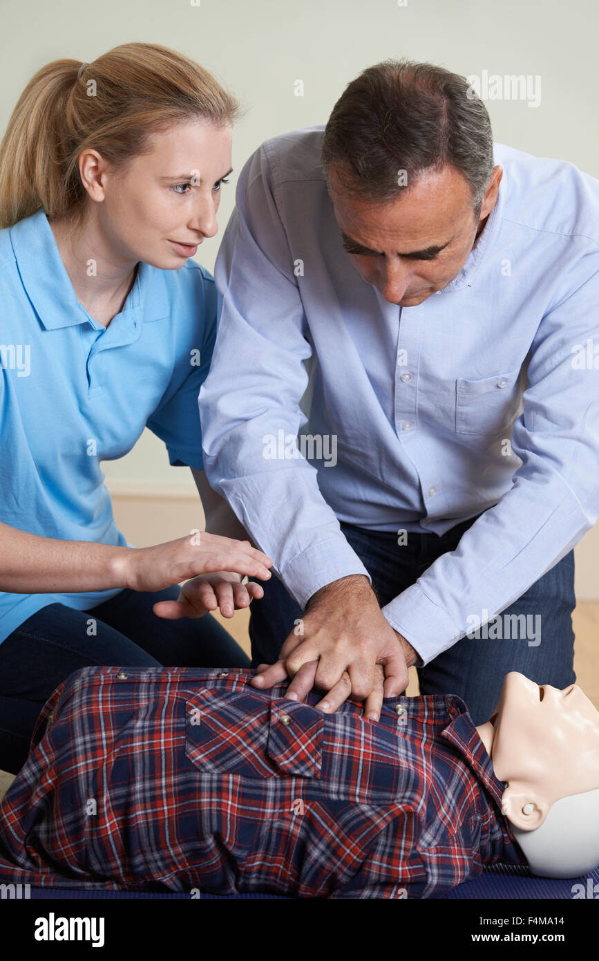 Woman Demonstrating CPR On Training Dummy In First Aid Class Stock ...