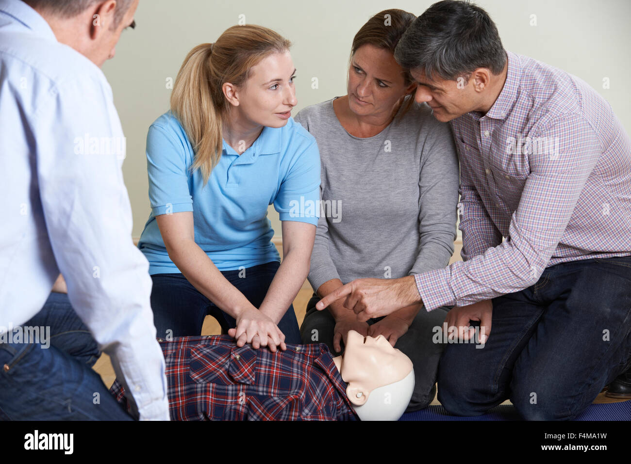 Woman Demonstrating CPR On Training Dummy In First Aid Class Stock ...