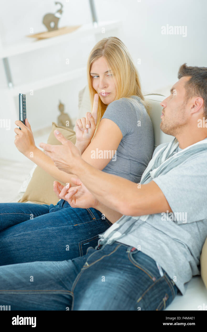 Couple fighting over the TV remote Stock Photo - Alamy