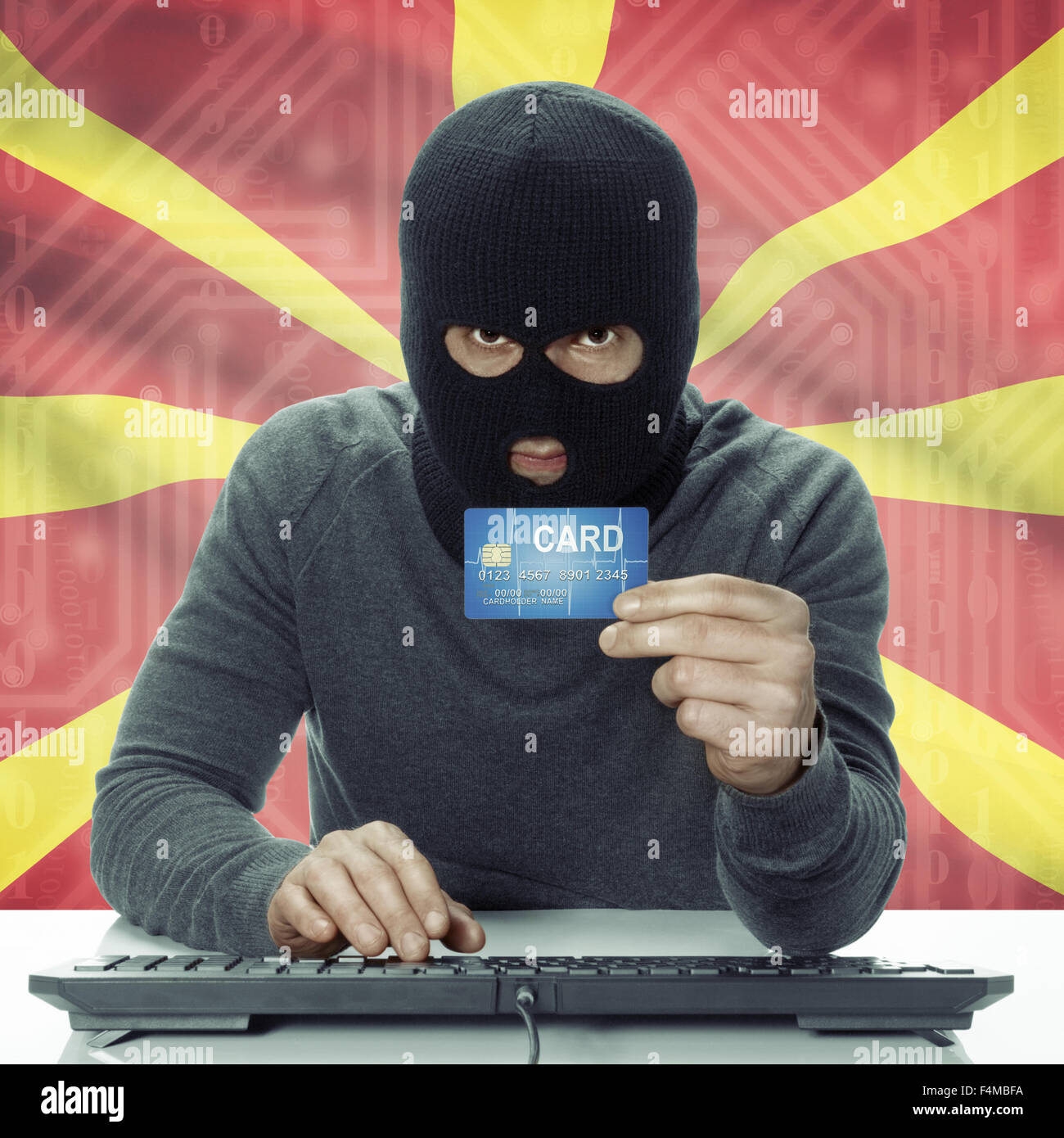 Dark-skinned hacker with credit card in hand and flag on background ...