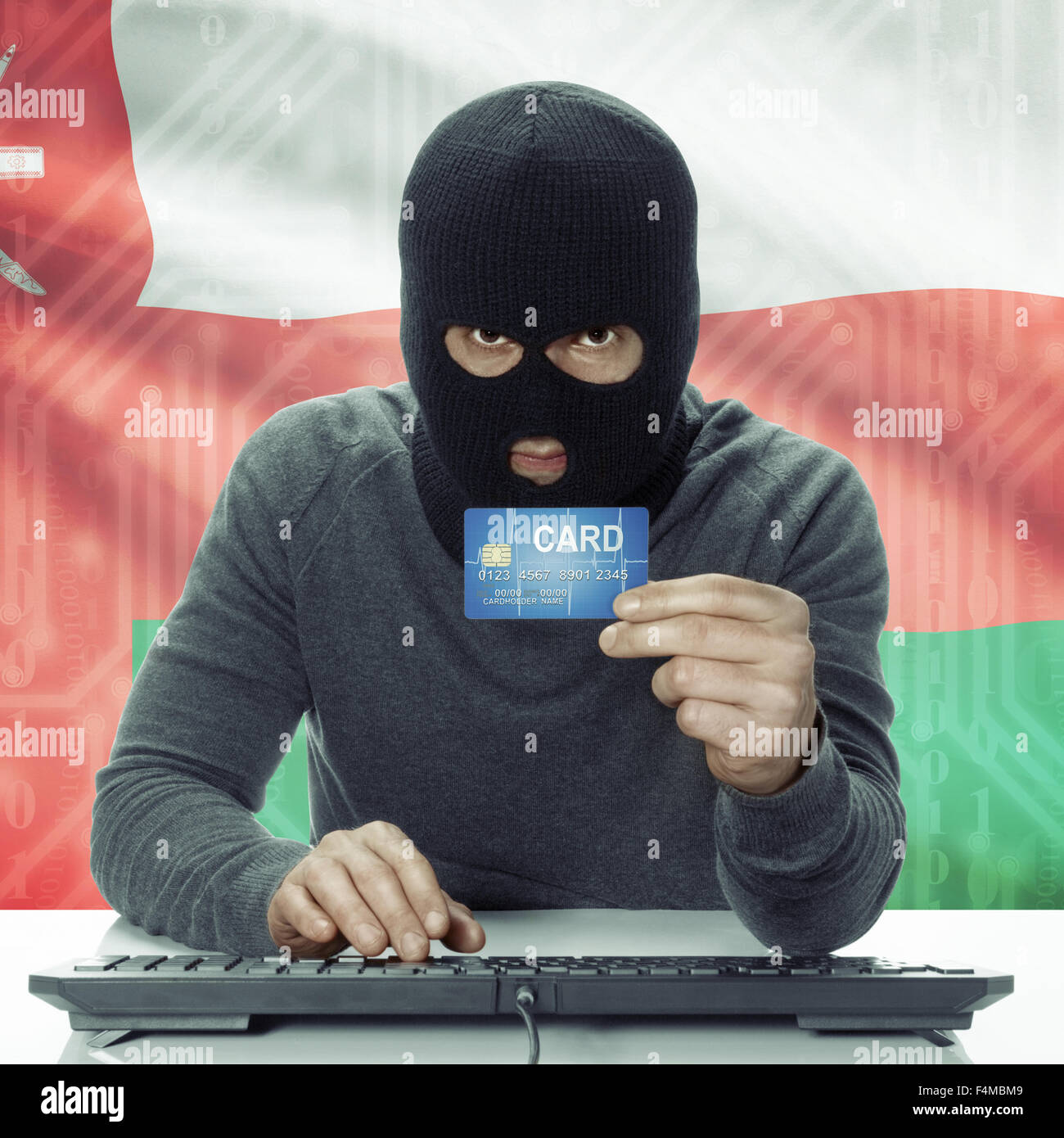 Dark-skinned hacker with credit card in hand and flag on background ...