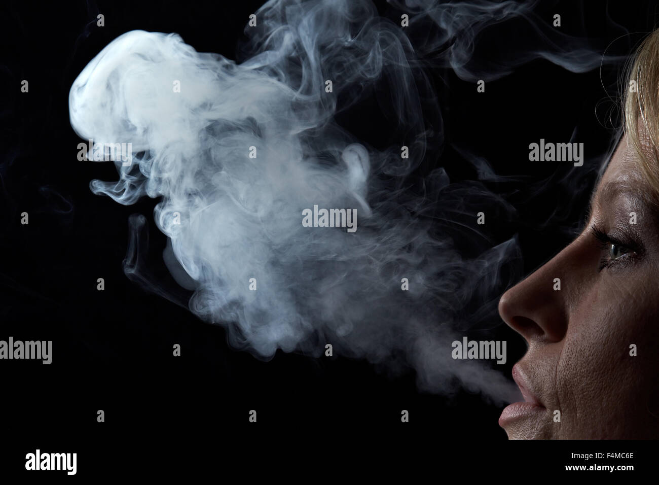 Woman smoking cigarette exhaling tobacco hi-res stock photography and ...