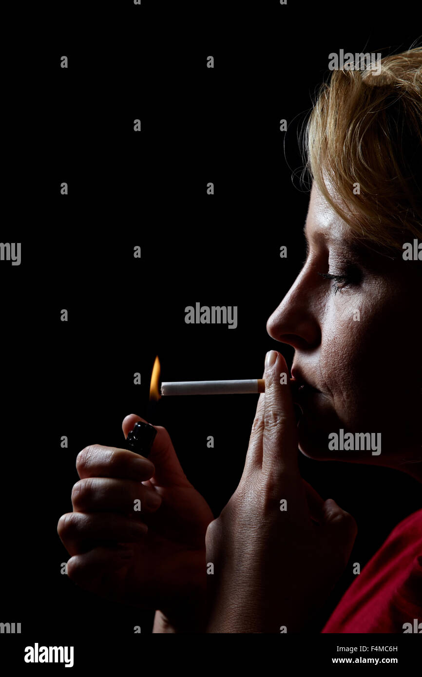 Woman lighting a cigarette with a lighter Stock Photo - Alamy