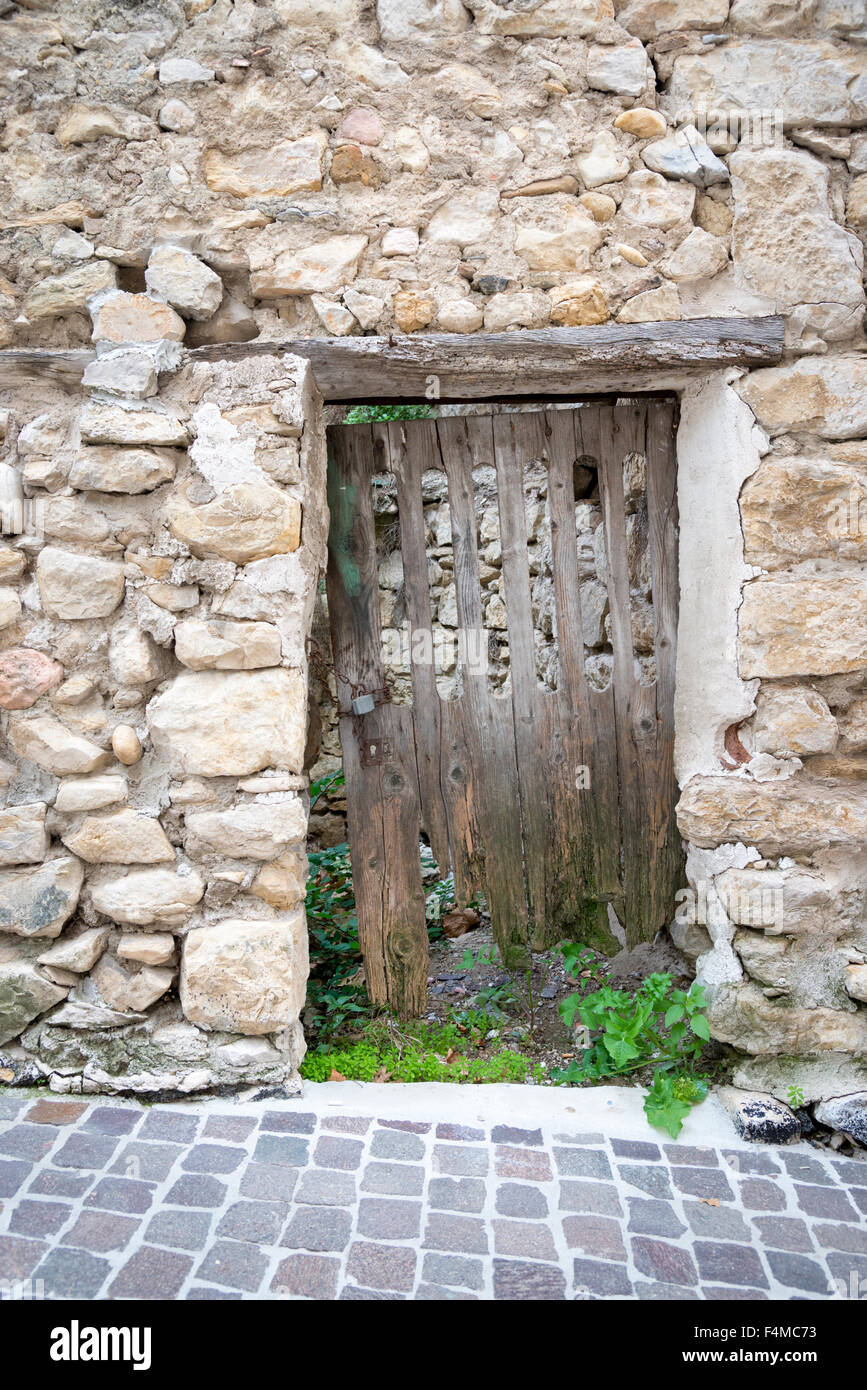 An on wooden door in a stone wall, rustic and rural Stock Photo - Alamy
