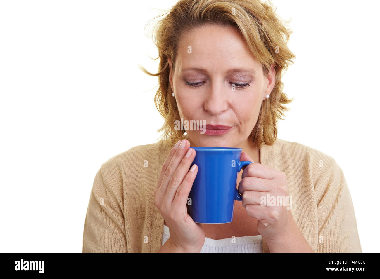 Woman blowing cool air in her cup of tea Stock Photo - Alamy