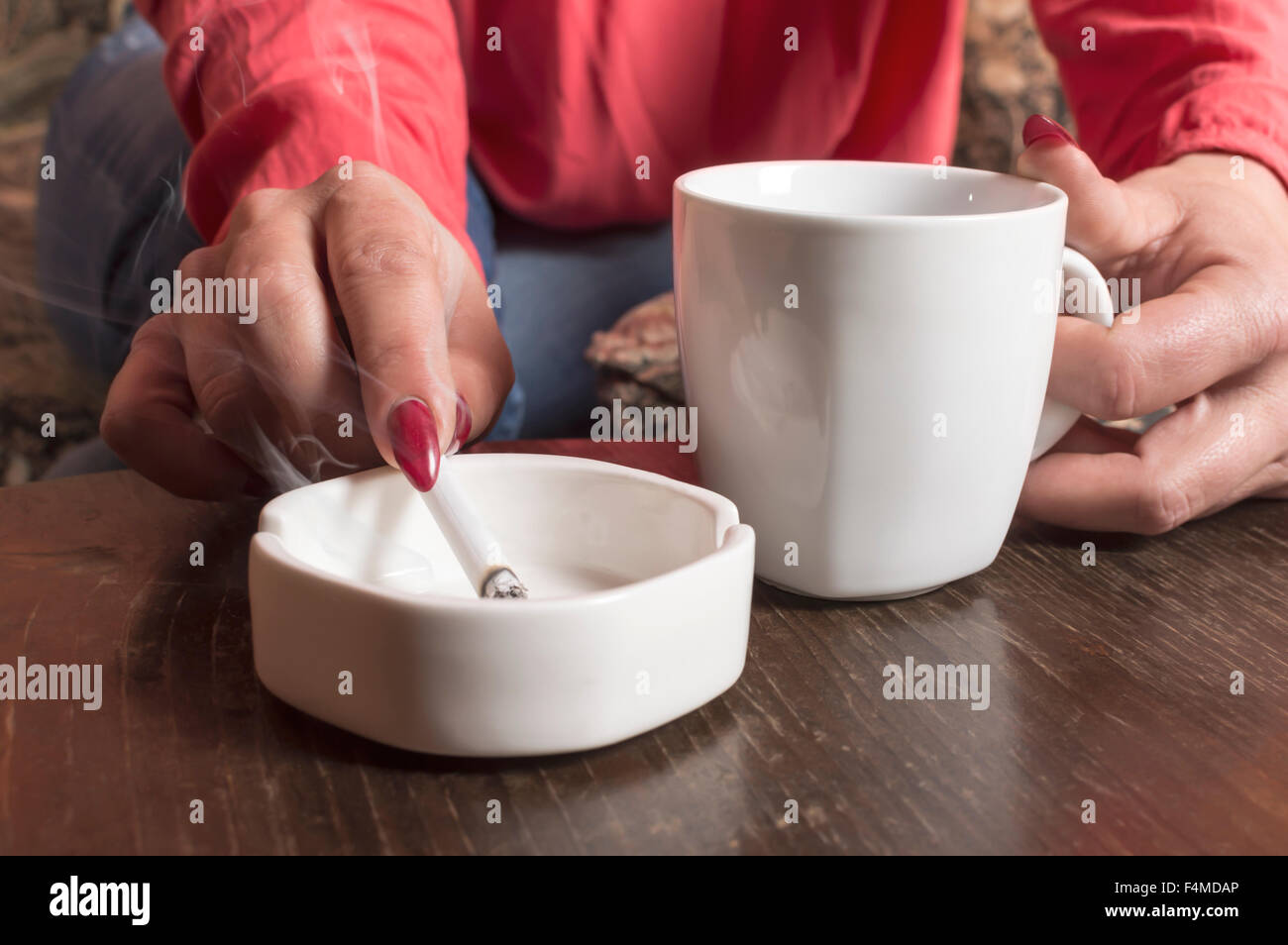 Woman smoking cigarette and using an ashtray. Selective focus Stock ...