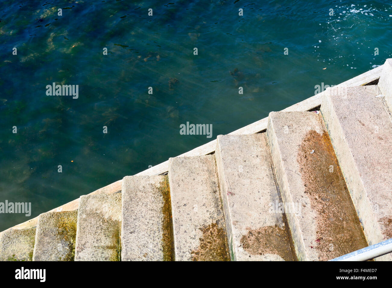 Concrete steps down from sea wall to water level Stock Photo - Alamy