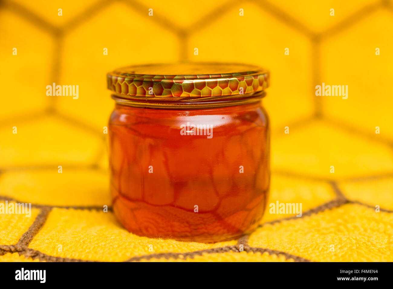 Jar of honey on honeycomb textile. Herb natural honey Stock Photo - Alamy