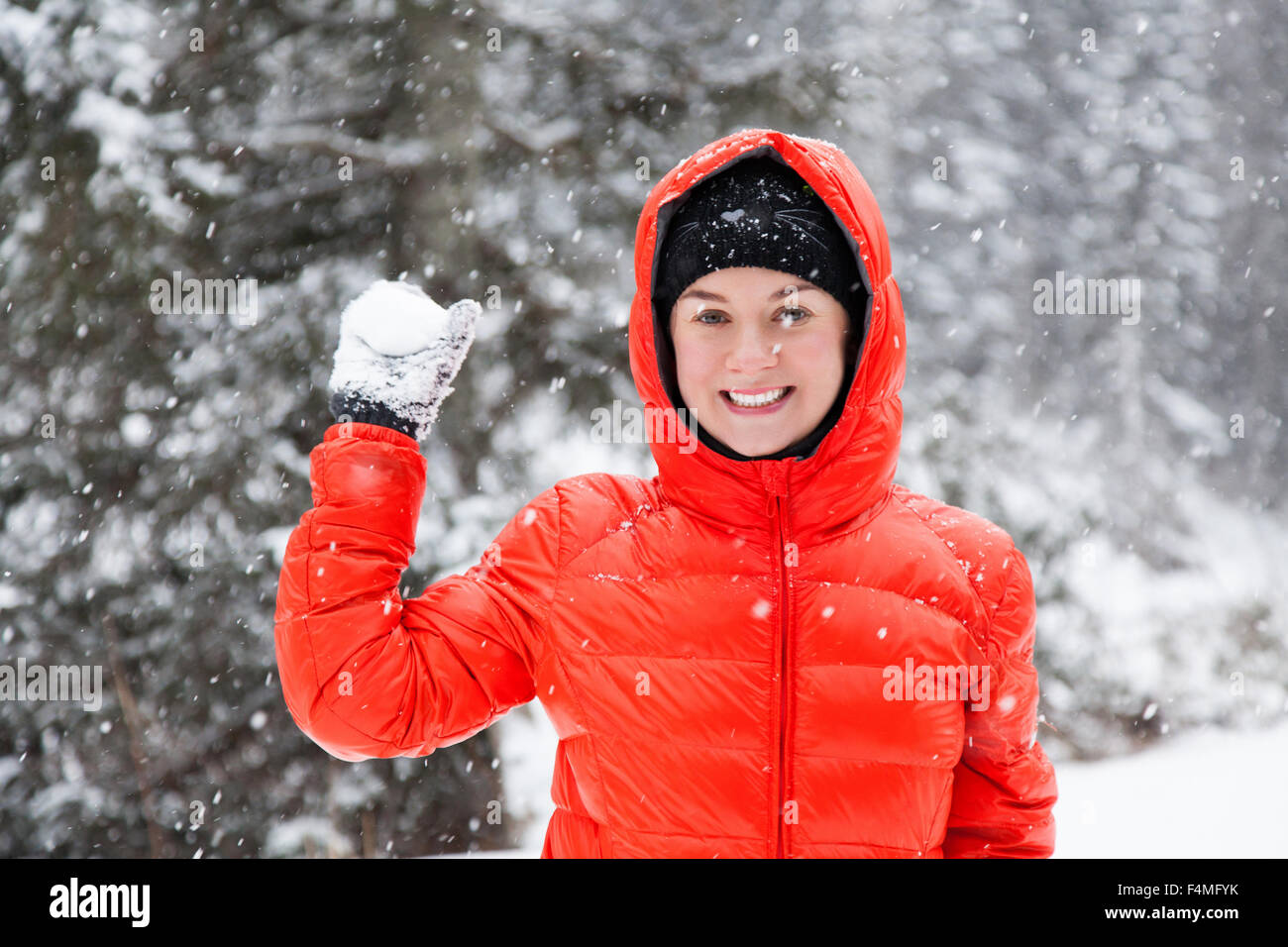 Pretty young woman playing snowballs Stock Photo - Alamy