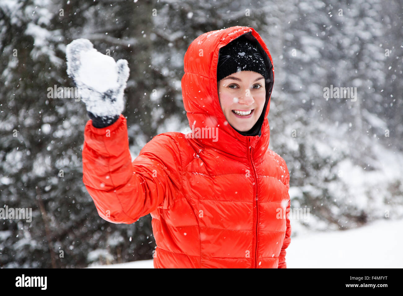 Pretty young woman playing snowballs Stock Photo - Alamy